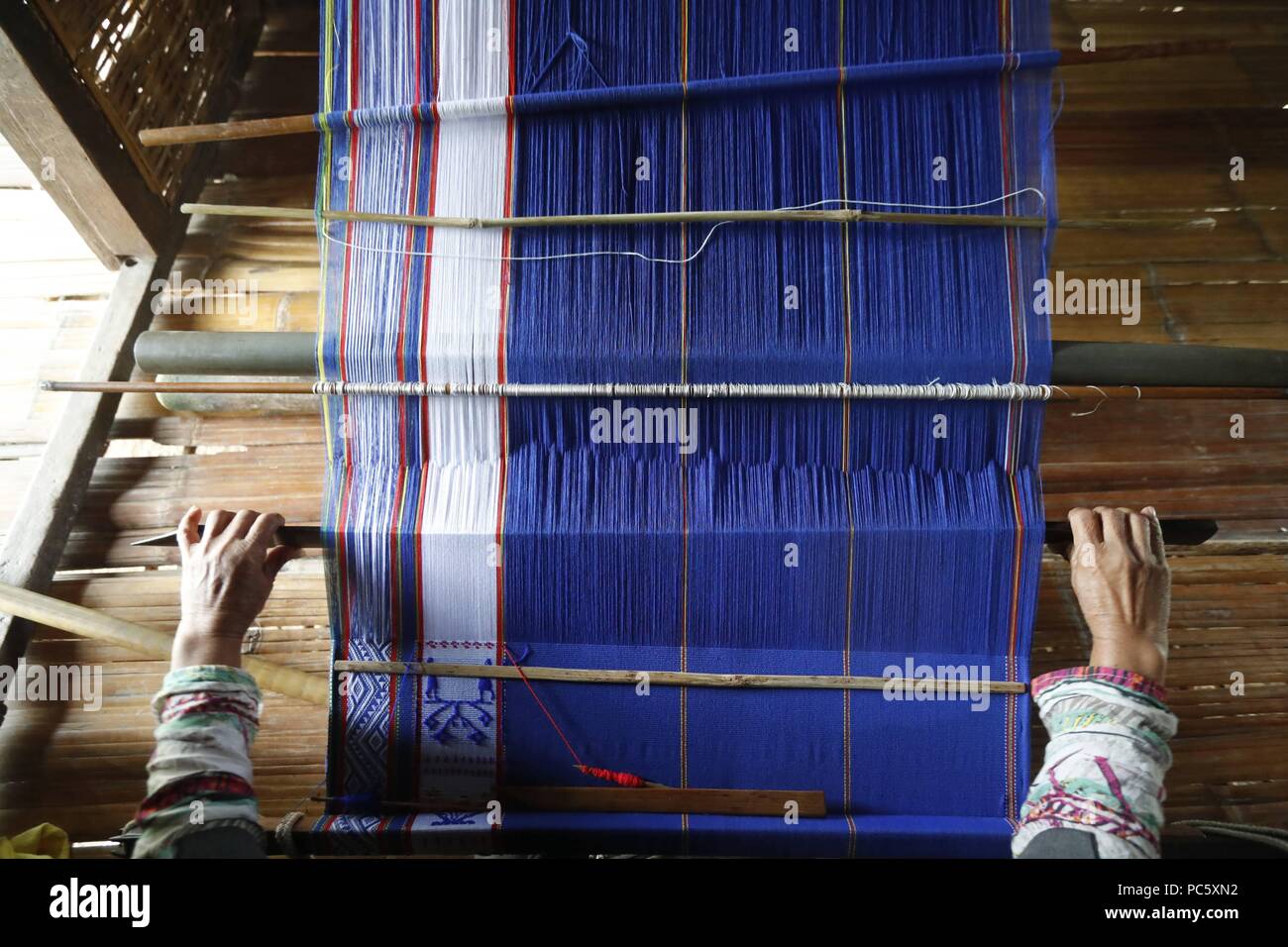 Bahnar (Ba Na) ethnic group. Woman weaving silk at wooden loom. Kon Tum ...