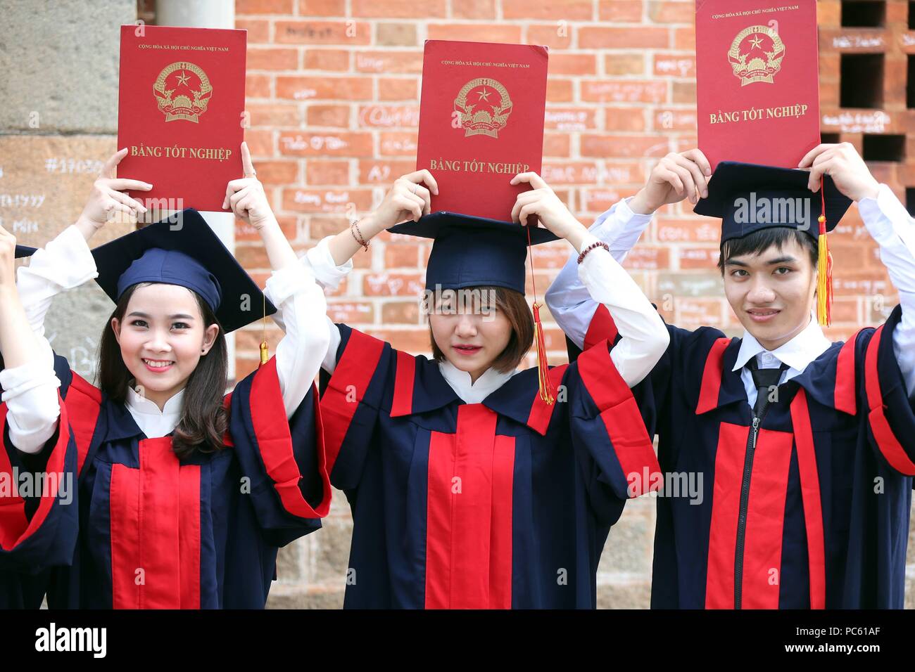 Group of Young Asian university students wearing cap and gown. Ho Chi ...