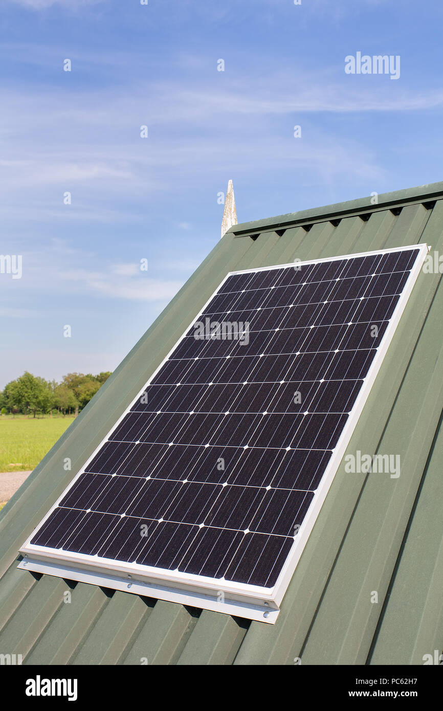 Solar panel on green roof of house with blue sky Stock Photo - Alamy