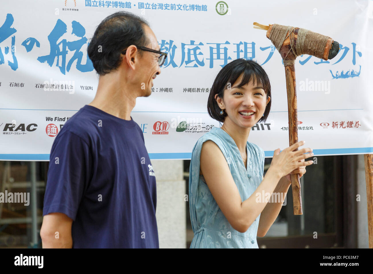 Japanese actress and singer Hikari Mitsushima (R) holds a stone axe ...