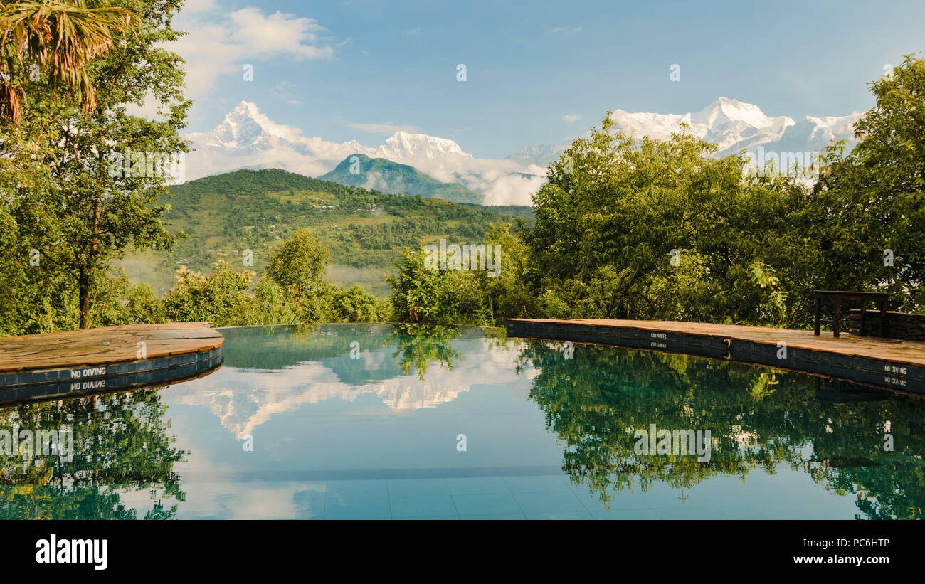 Annapurna mountain range reflecting in an infinity pool in a resort ...