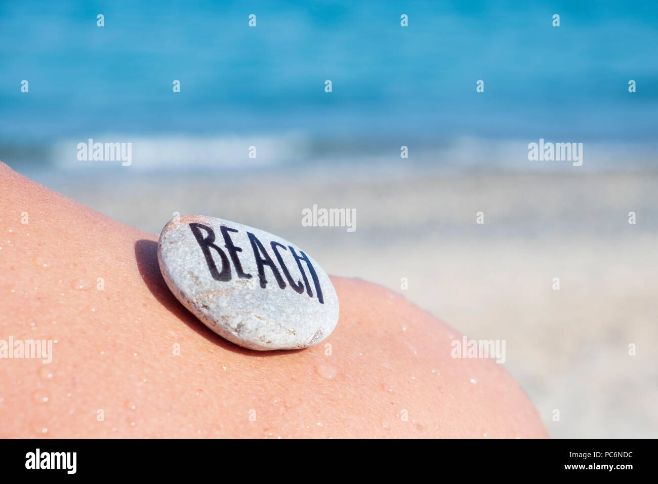 closeup of a young caucasian man seen from behind on the beach, in ...