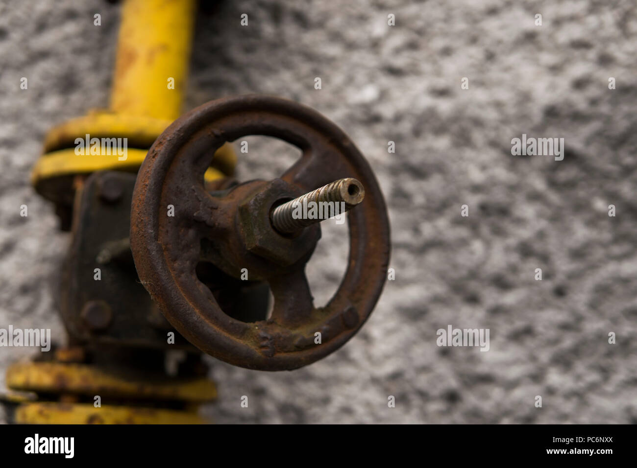 Old weathered gas crane and pipe on the background of a gray wall. Old ...