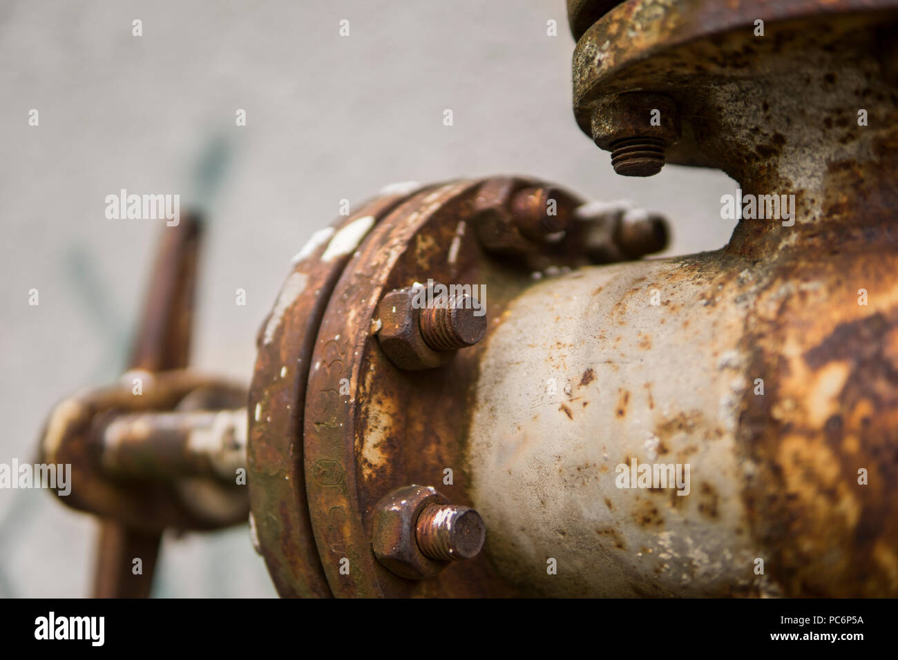 Old weathered gas crane and pipe on the background of a gray wall. Old ...