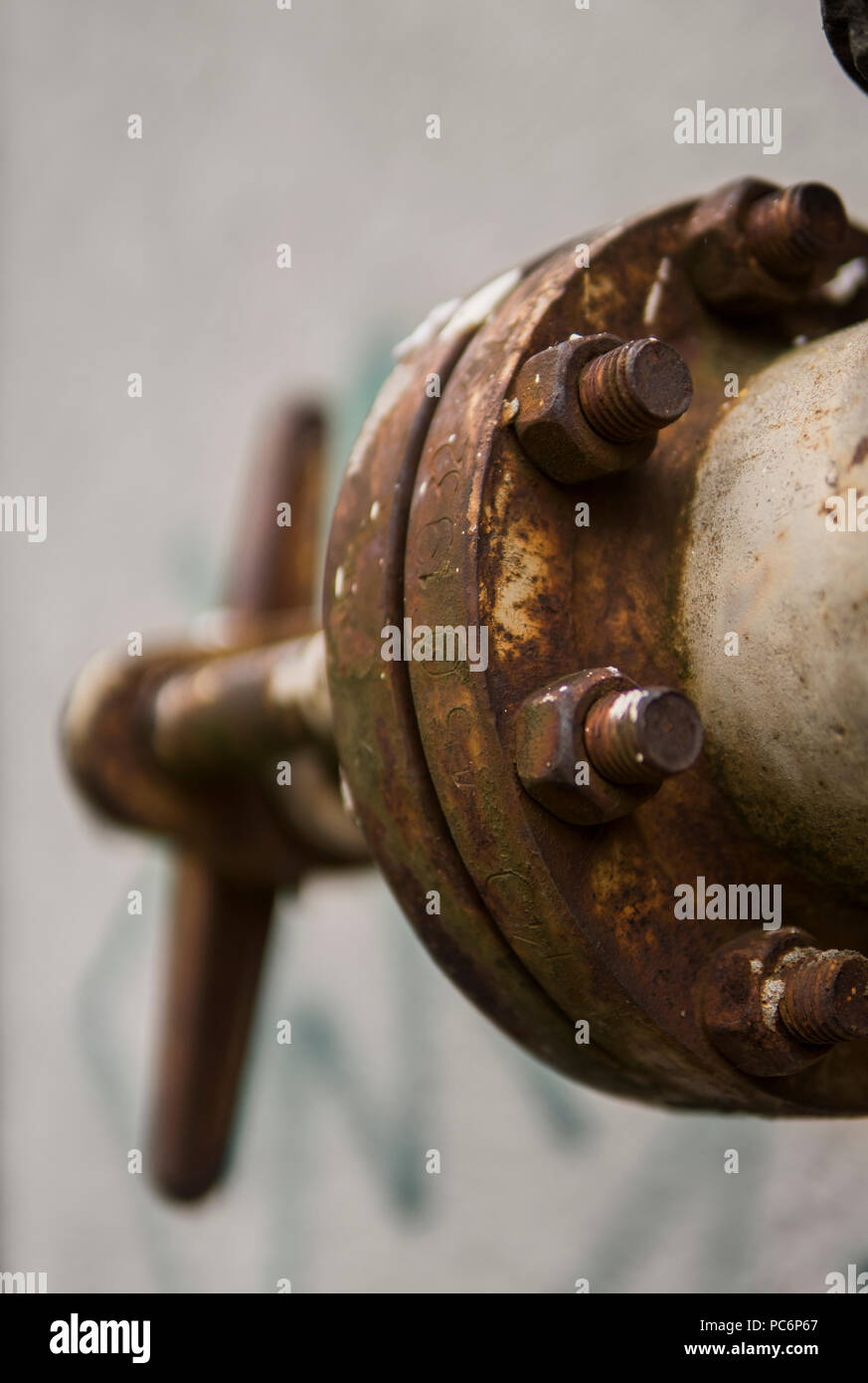 Old weathered gas crane and pipe on the background of a gray wall. Old ...