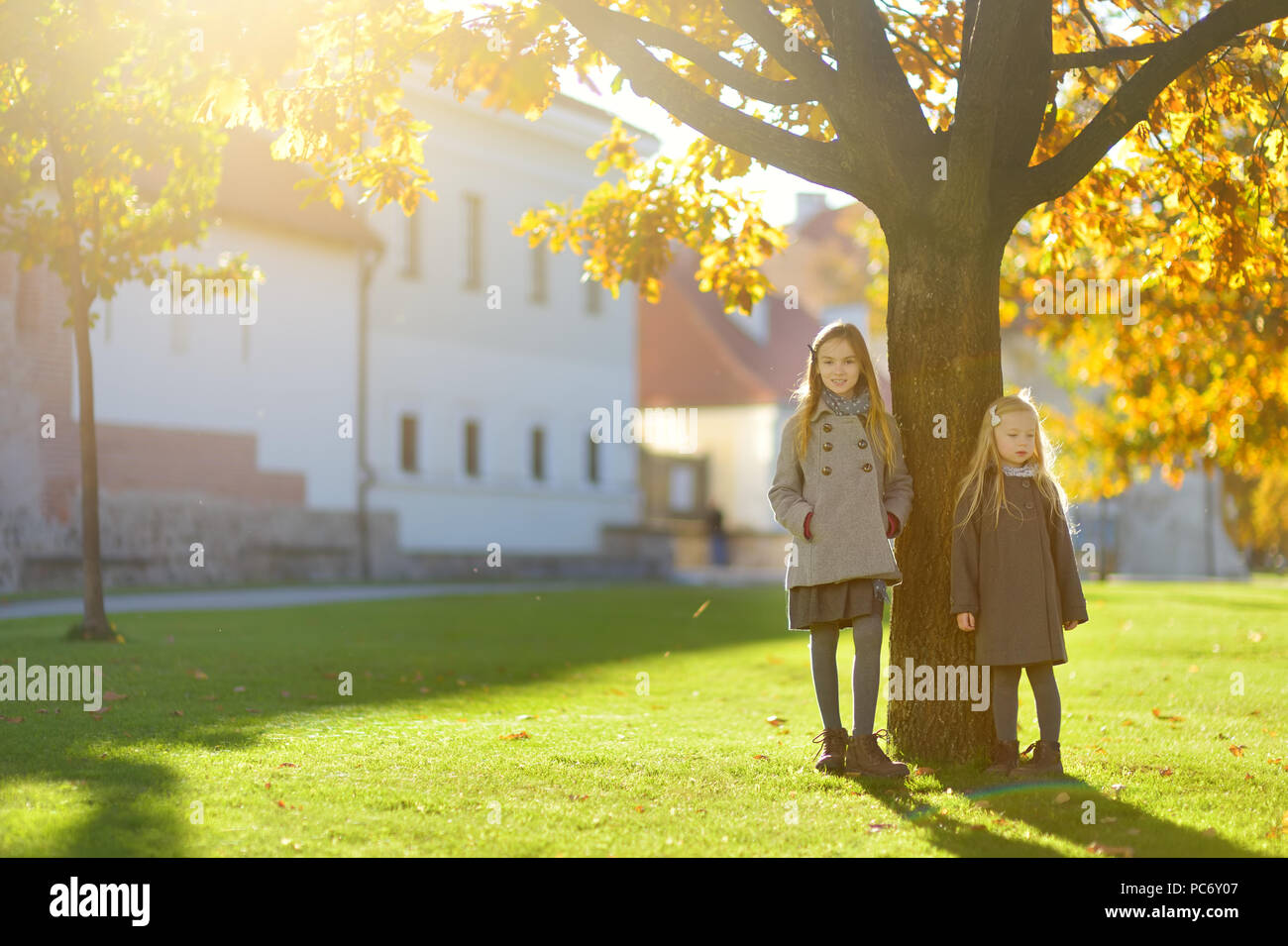 Two cute little girls having fun on beautiful autumn day. Happy ...