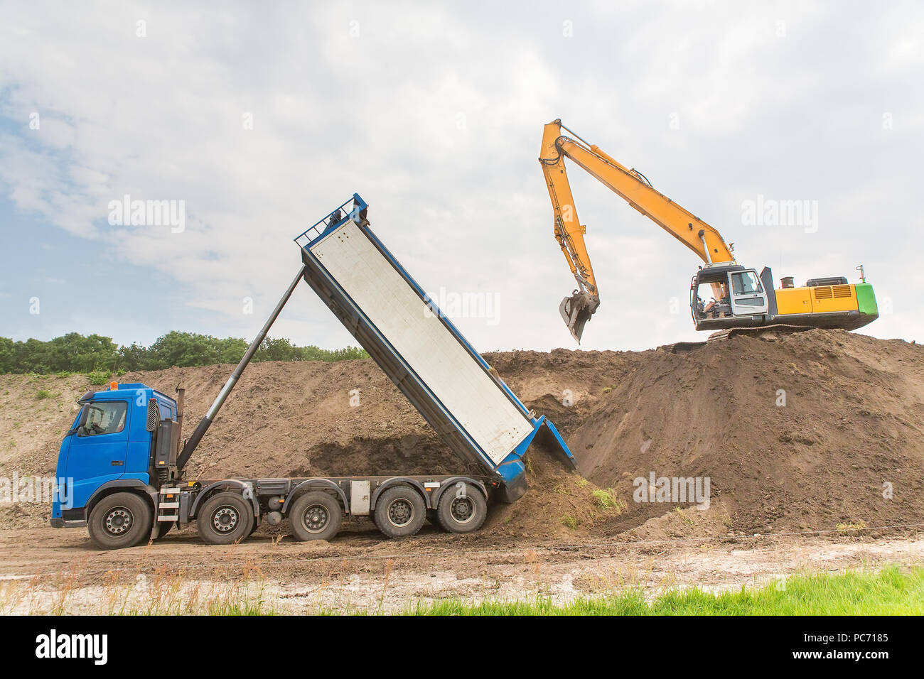 Truck and excavator together build a sound barrier of sand Stock Photo ...