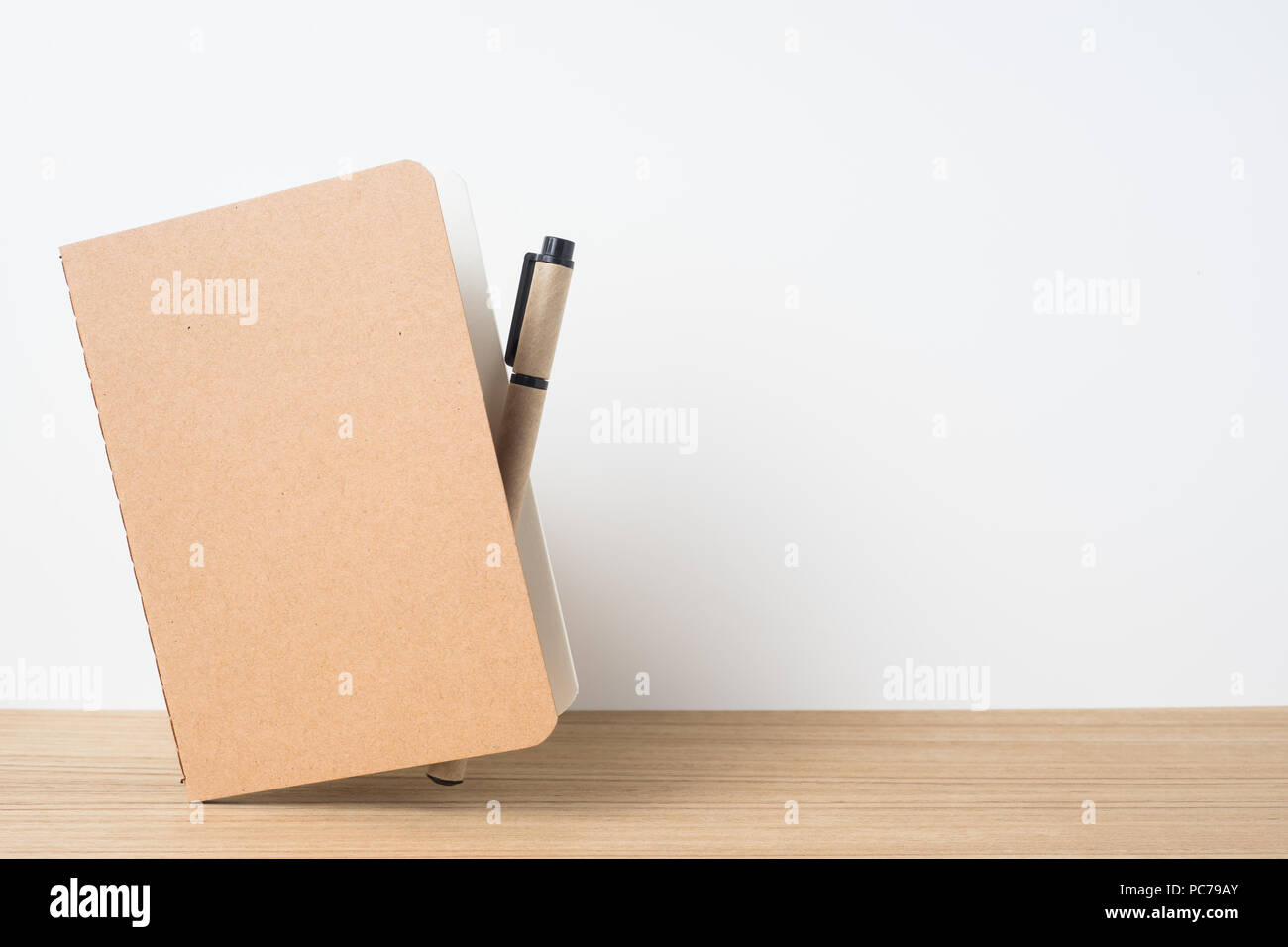 Design concept - front view of floating kraft notebook and on wooden ...