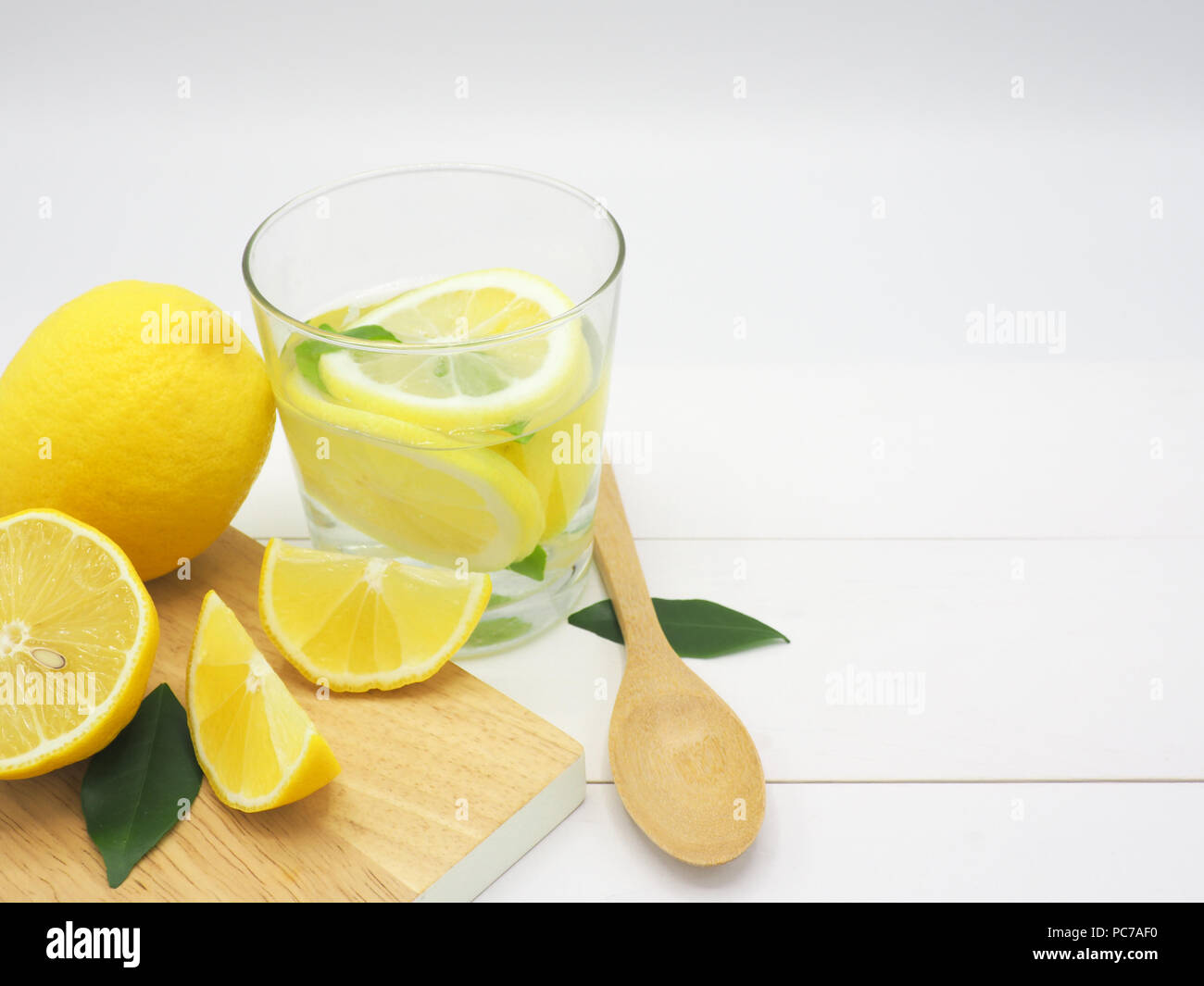 Fresh lemon in water and lemon slice on white wood background Stock ...