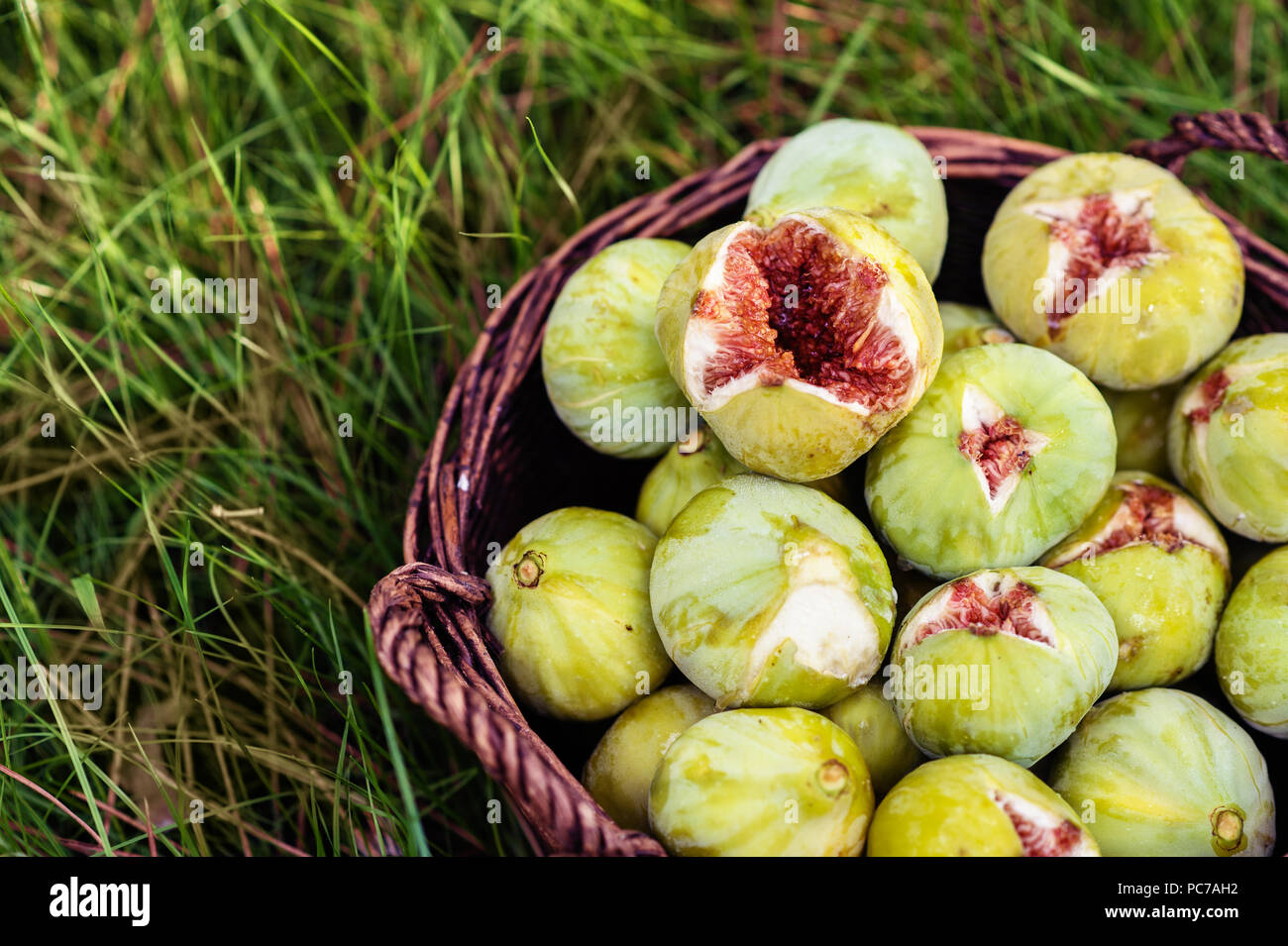 Fresh green figs with green leaves in a wicker basket Stock Photo - Alamy