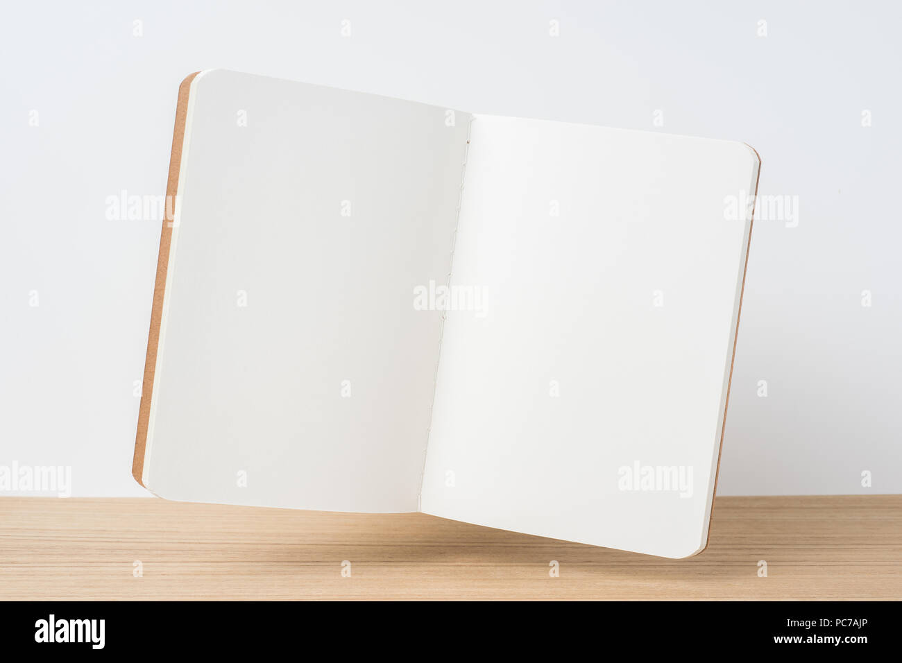 Design concept - front view of floating kraft notebook and on wooden ...