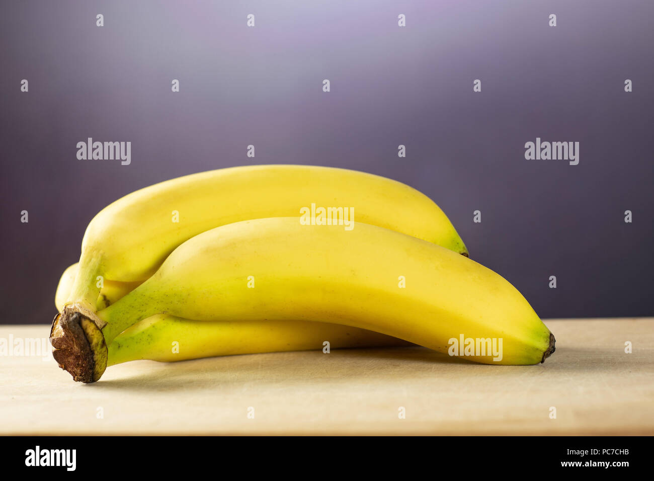 Group of five whole fresh yellow banana one ripe cluster with grey ...