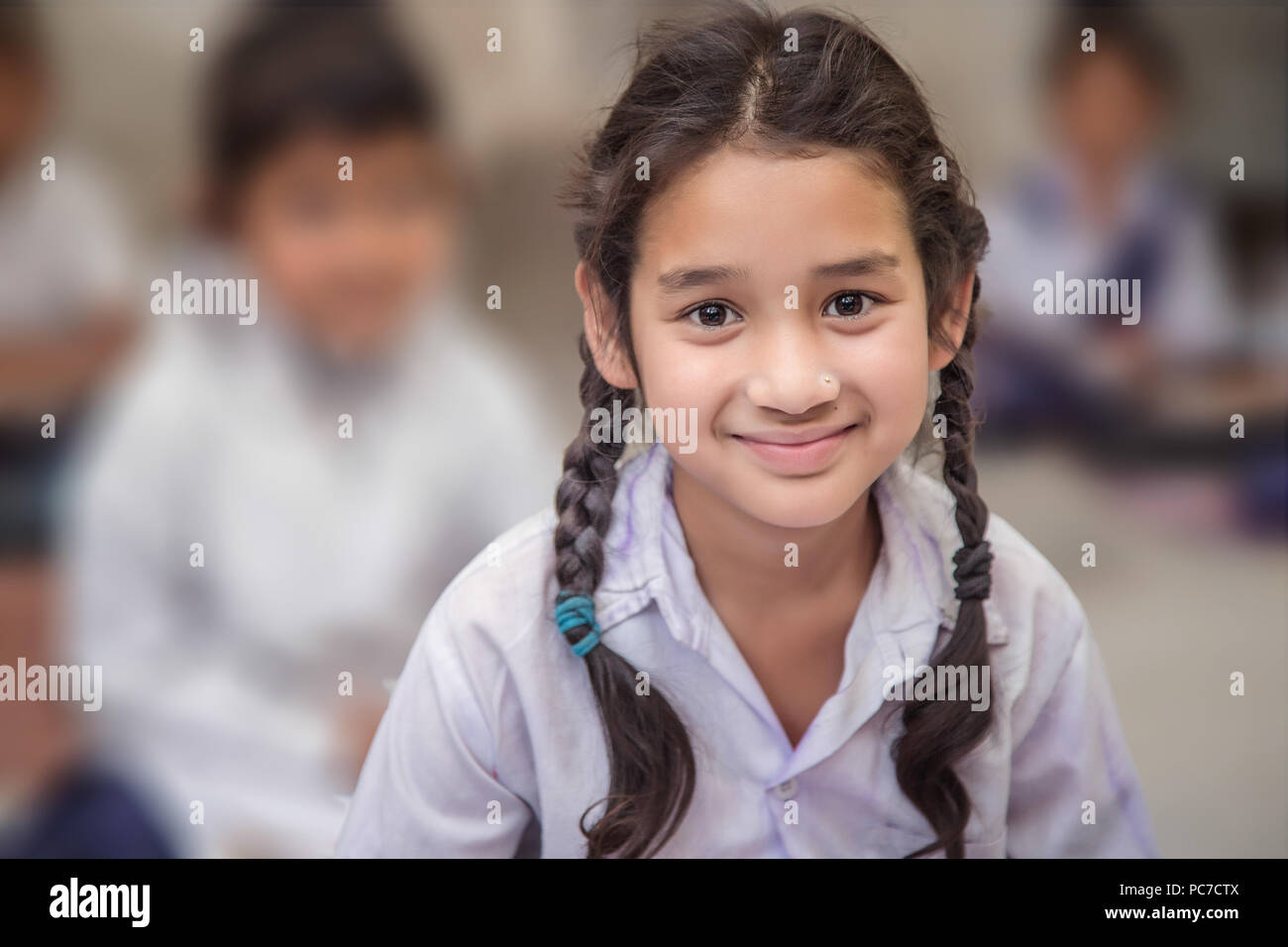 Girl sitting on the floor of her government primary school in uniform ...