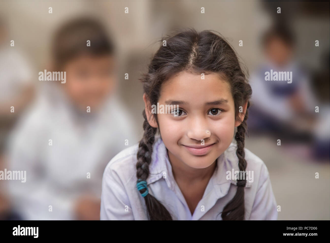 Girl sitting on the floor of her government primary school in uniform ...