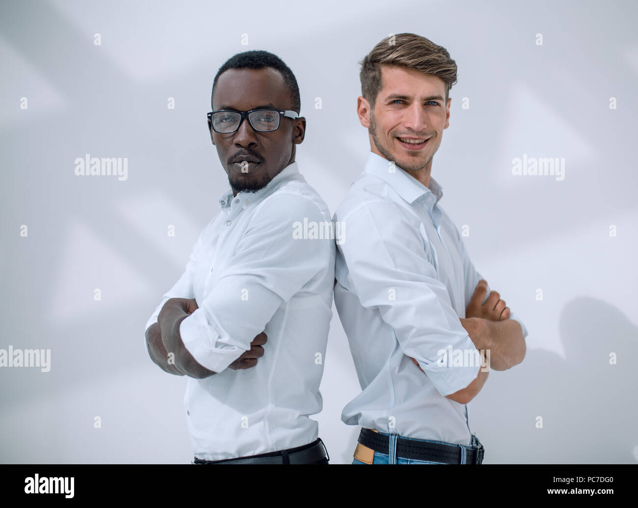 two young business partners standing back to back Stock Photo - Alamy