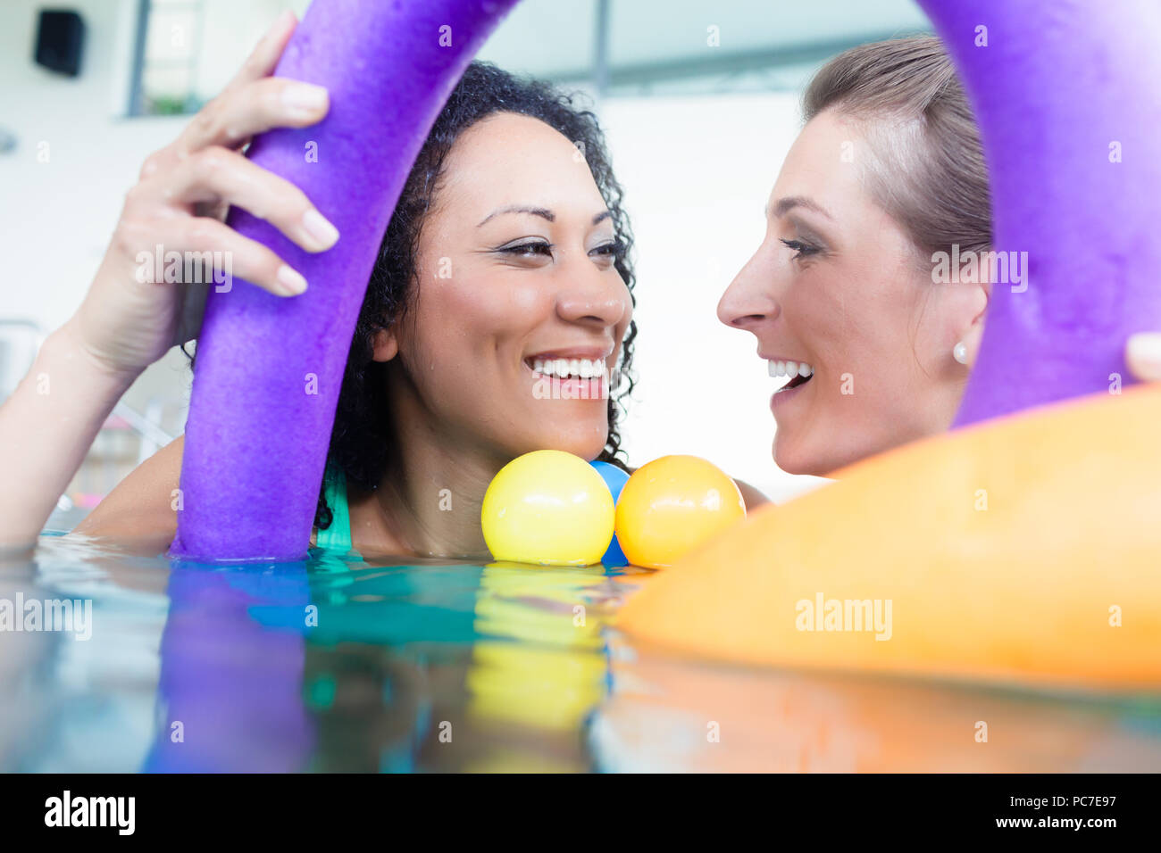 Two female friends attending swimming course Stock Photo - Alamy