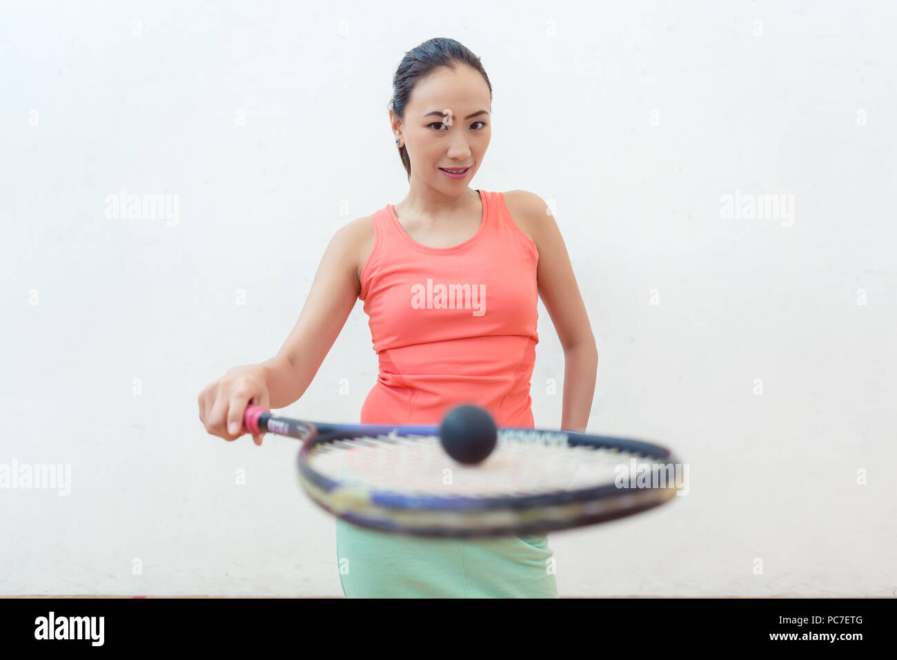 Close-up of a rubber hollow ball on the new squash racket of a fit ...