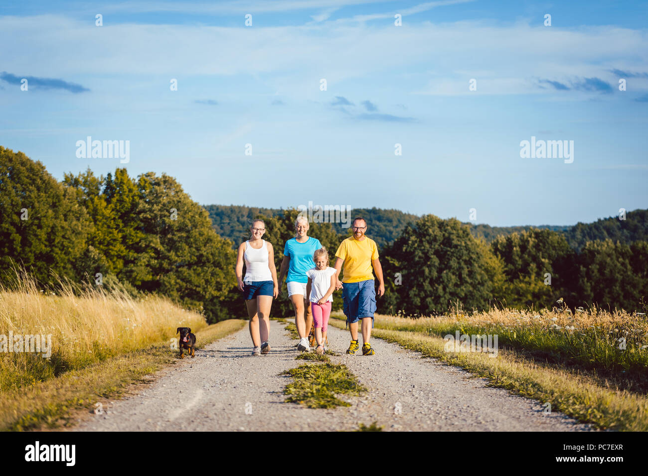 Family walking their dog on a dirt path Stock Photo - Alamy