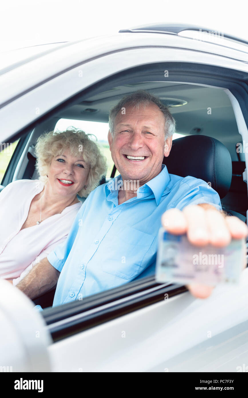 Portrait of a happy senior man showing his driving license Stock Photo ...