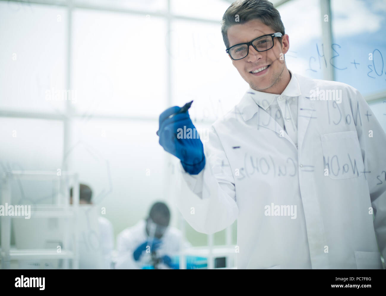 successful scientist writes a formula on a glass Board Stock Photo - Alamy