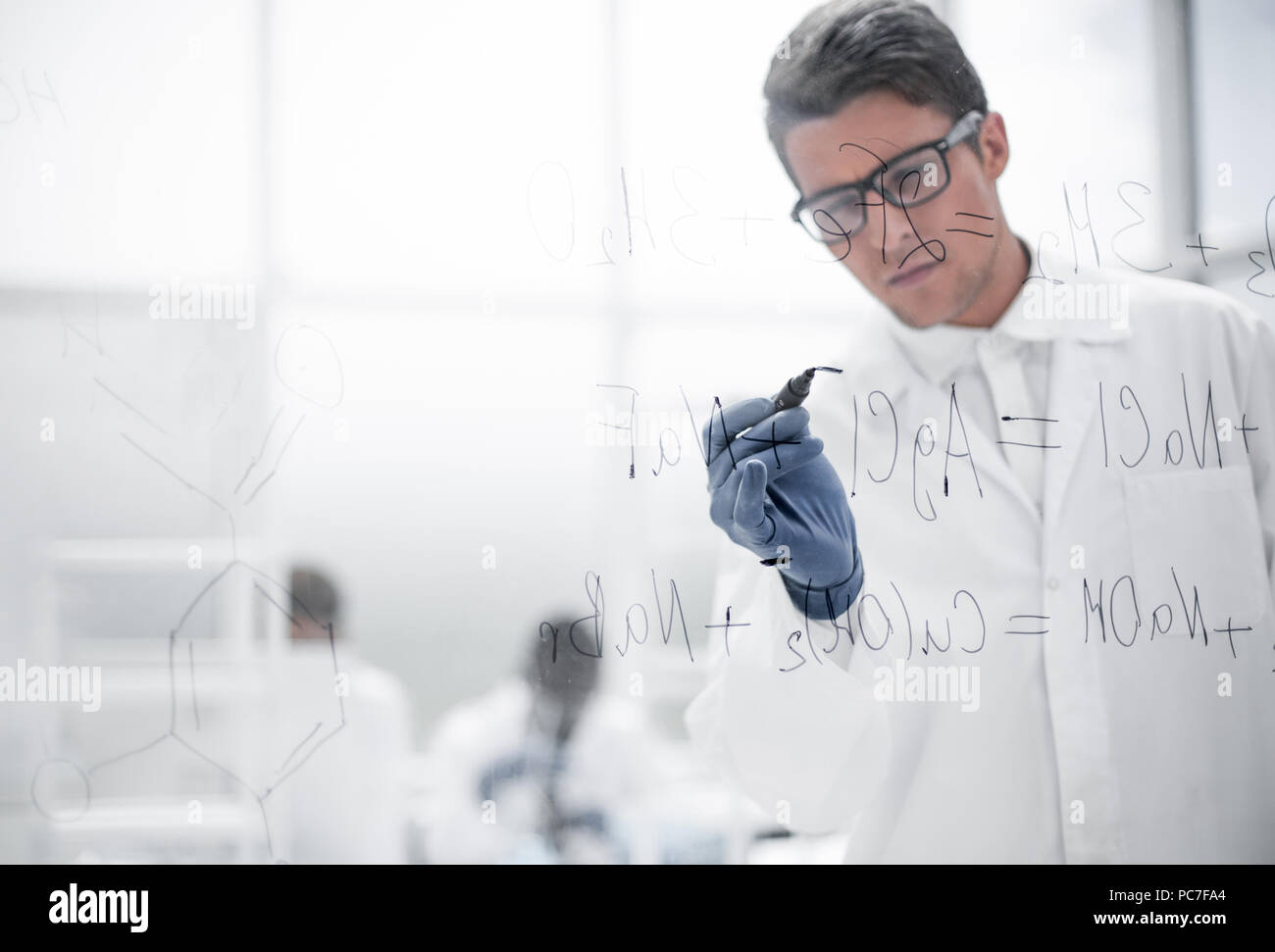 serious scientist writes a formula on a glass Board Stock Photo - Alamy