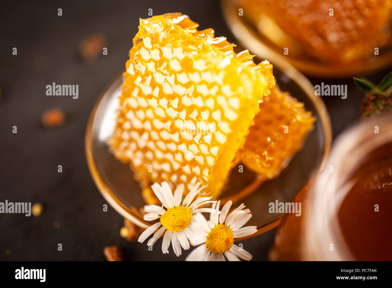 Honey jar and dipper with leaking honey Stock Photo - Alamy