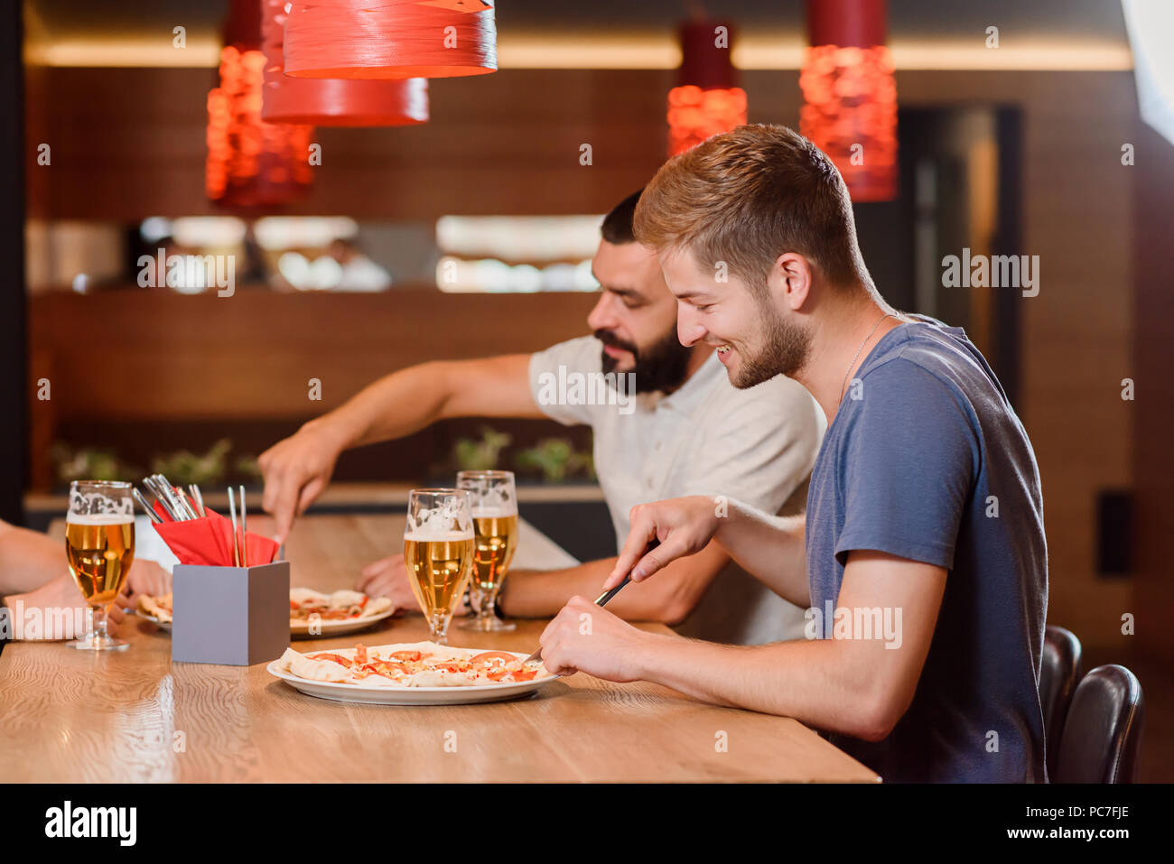 Two men eating food sitting hi-res stock photography and images - Alamy