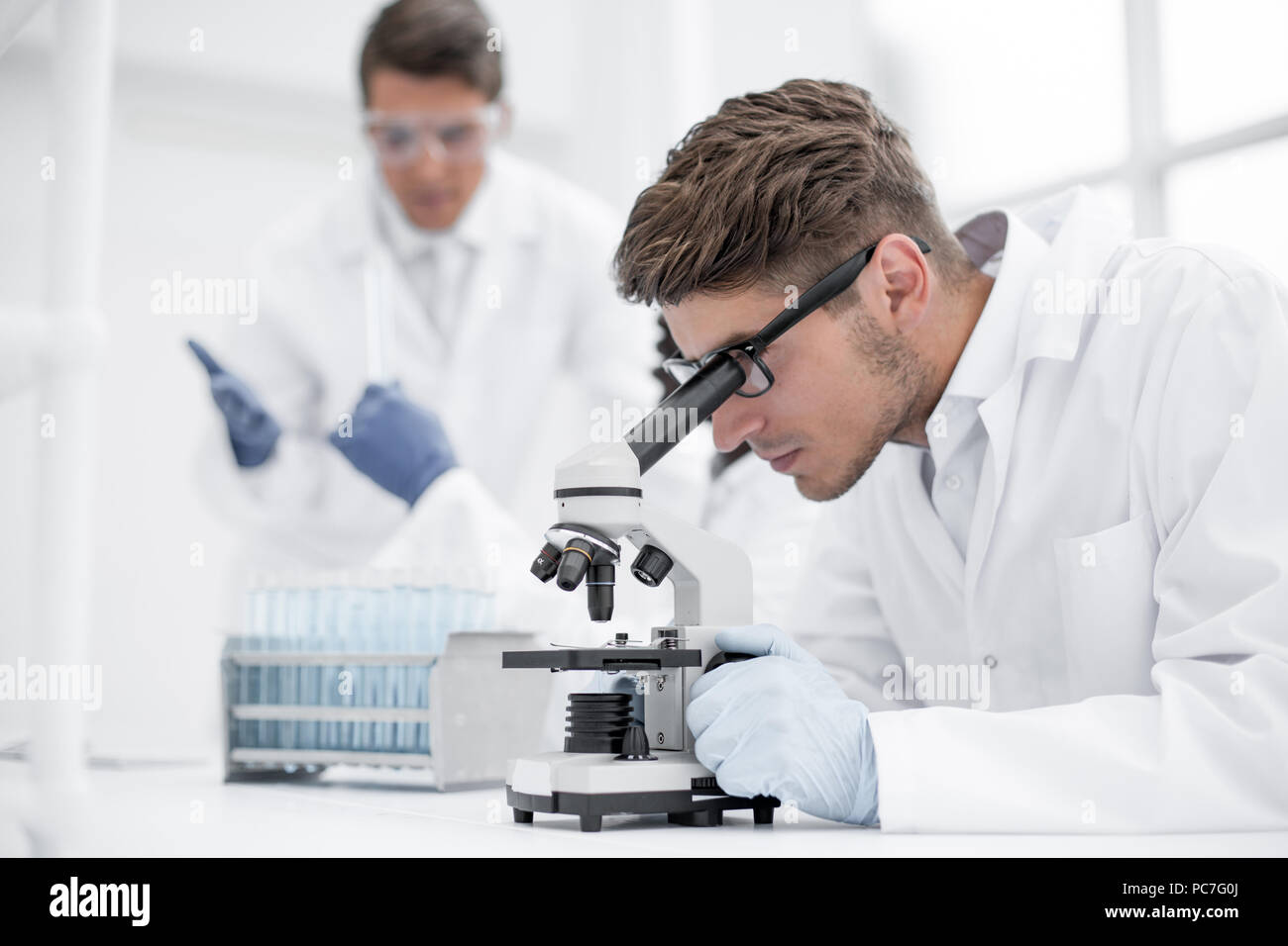 close up.the scientist looks through the microscope Stock Photo - Alamy