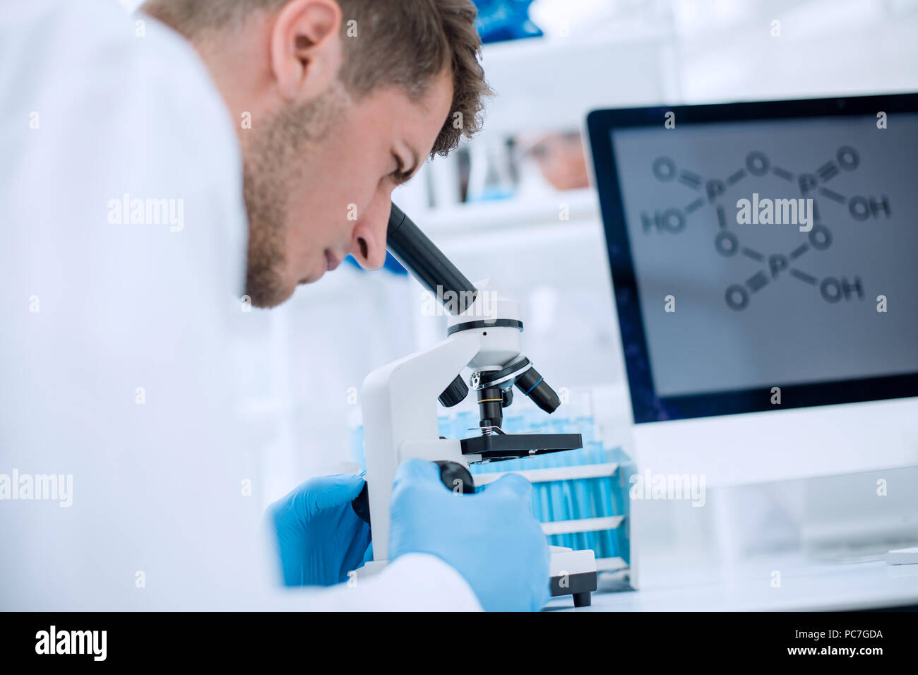 Scientist looking through a microscope in a laboratory Stock Photo - Alamy
