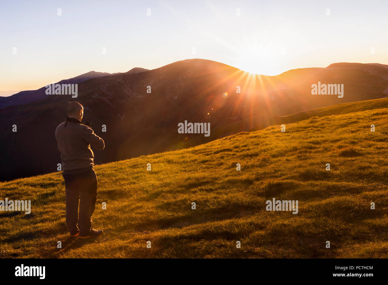 tourist on the mountain at sunset Stock Photo - Alamy