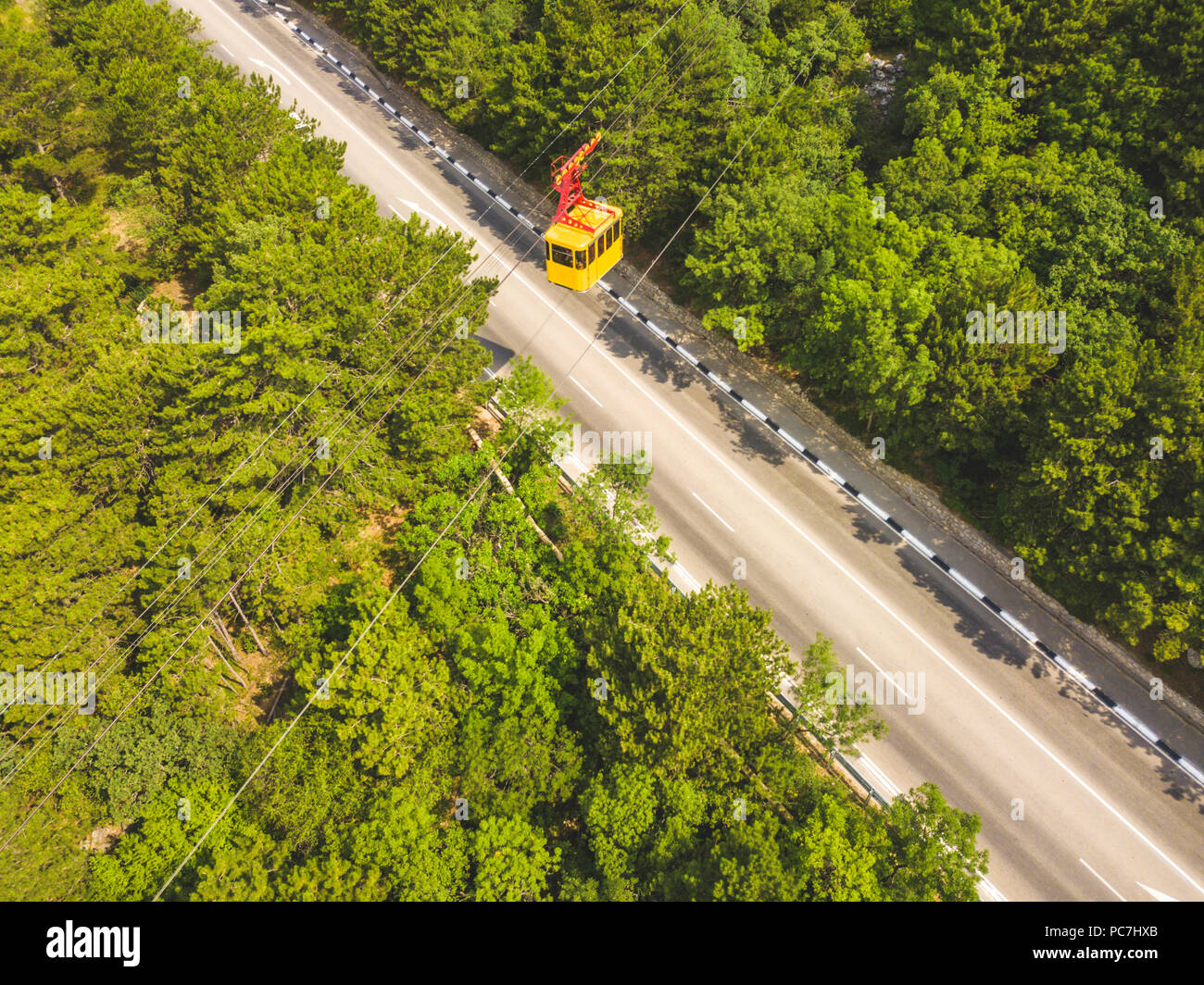 aerial top view of cable car cabin moving to the top of mountain on a ...