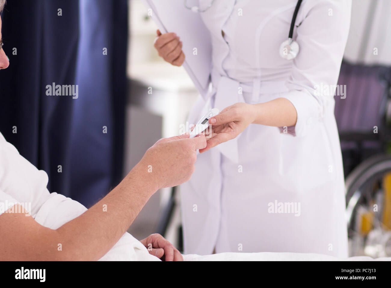 Female nurse giving her patient thermometer. Picture of doctor wearing ...