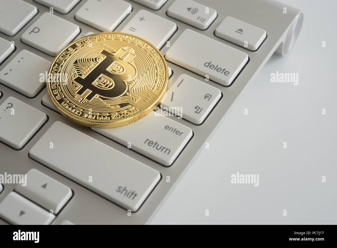 Golden Bitcoin Cryptocurrency gold coin on computer keyboard and return ...