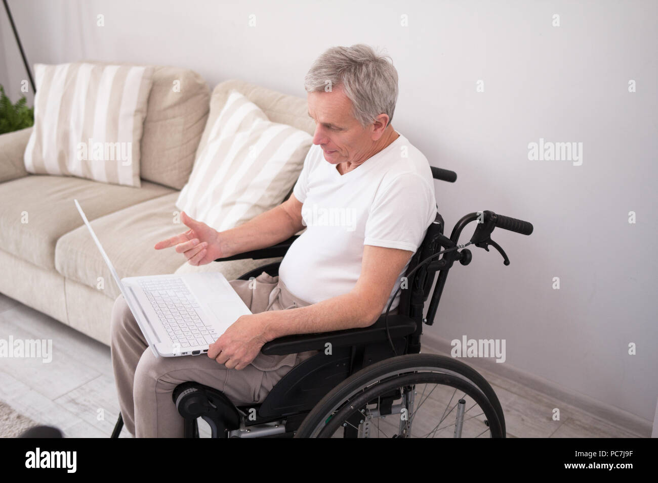 Man in wheelchair working with computer. Senior disabled man sitting in ...