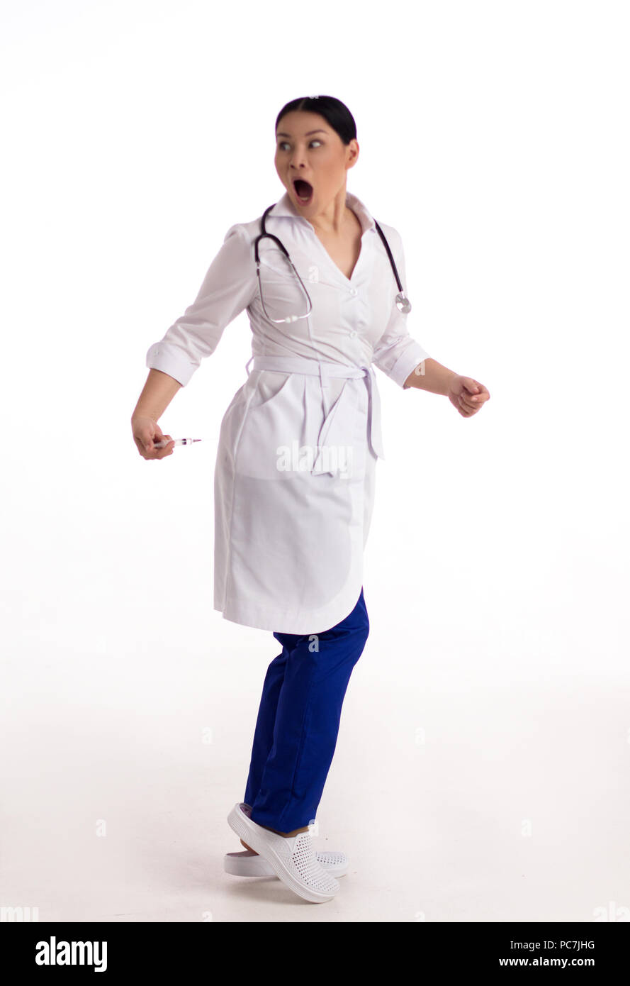 Frightened nurse with syringe on white background. Silly asian doctor ...