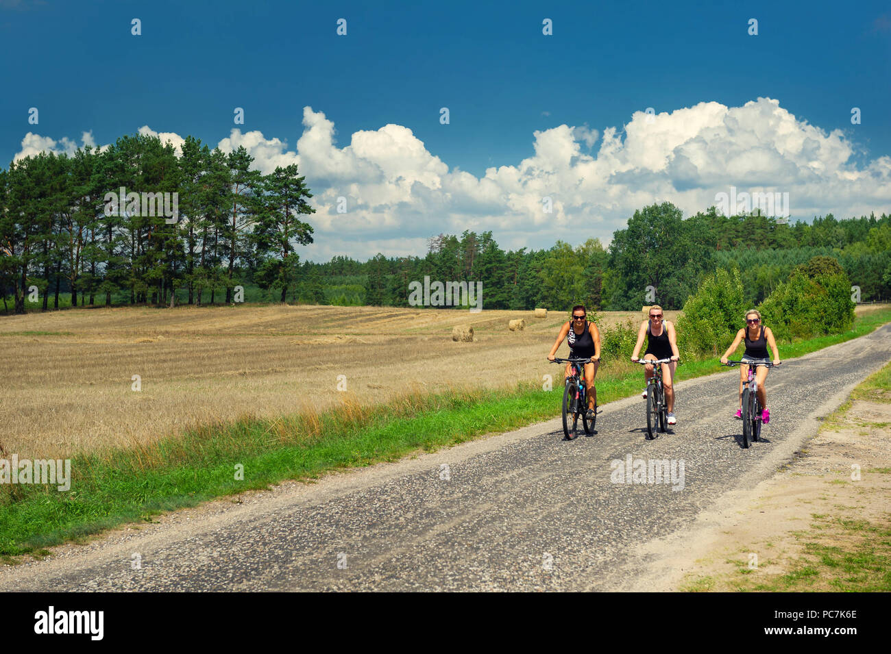 three women ride bicycles Stock Photo - Alamy