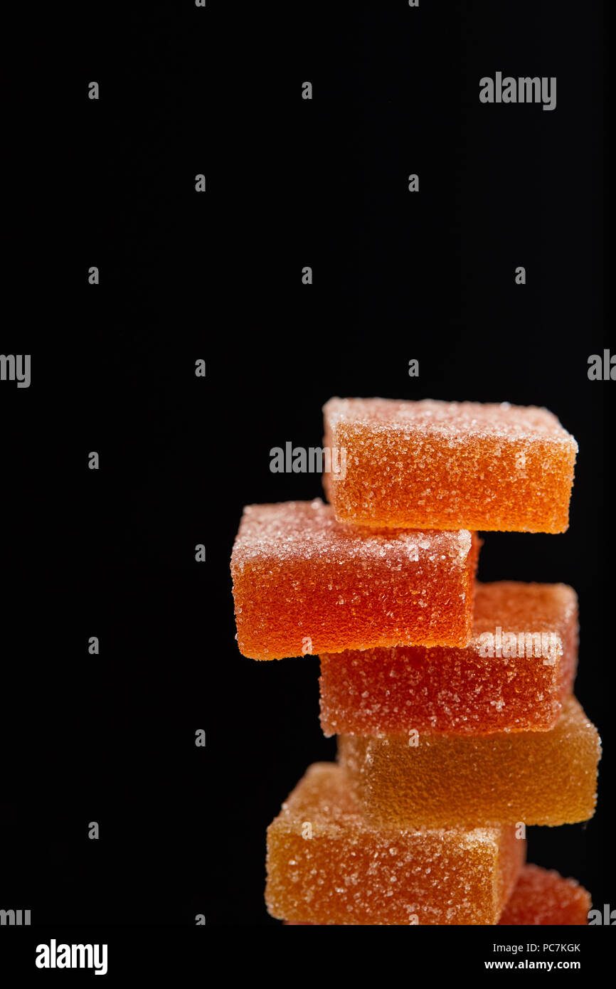 closeup view of stack of jelly candies isolated on black background ...