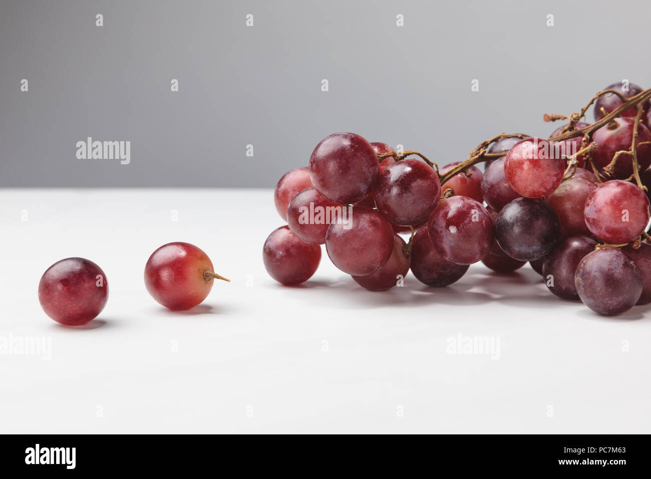 Close up view of pile of red grapes on gray Stock Photo - Alamy