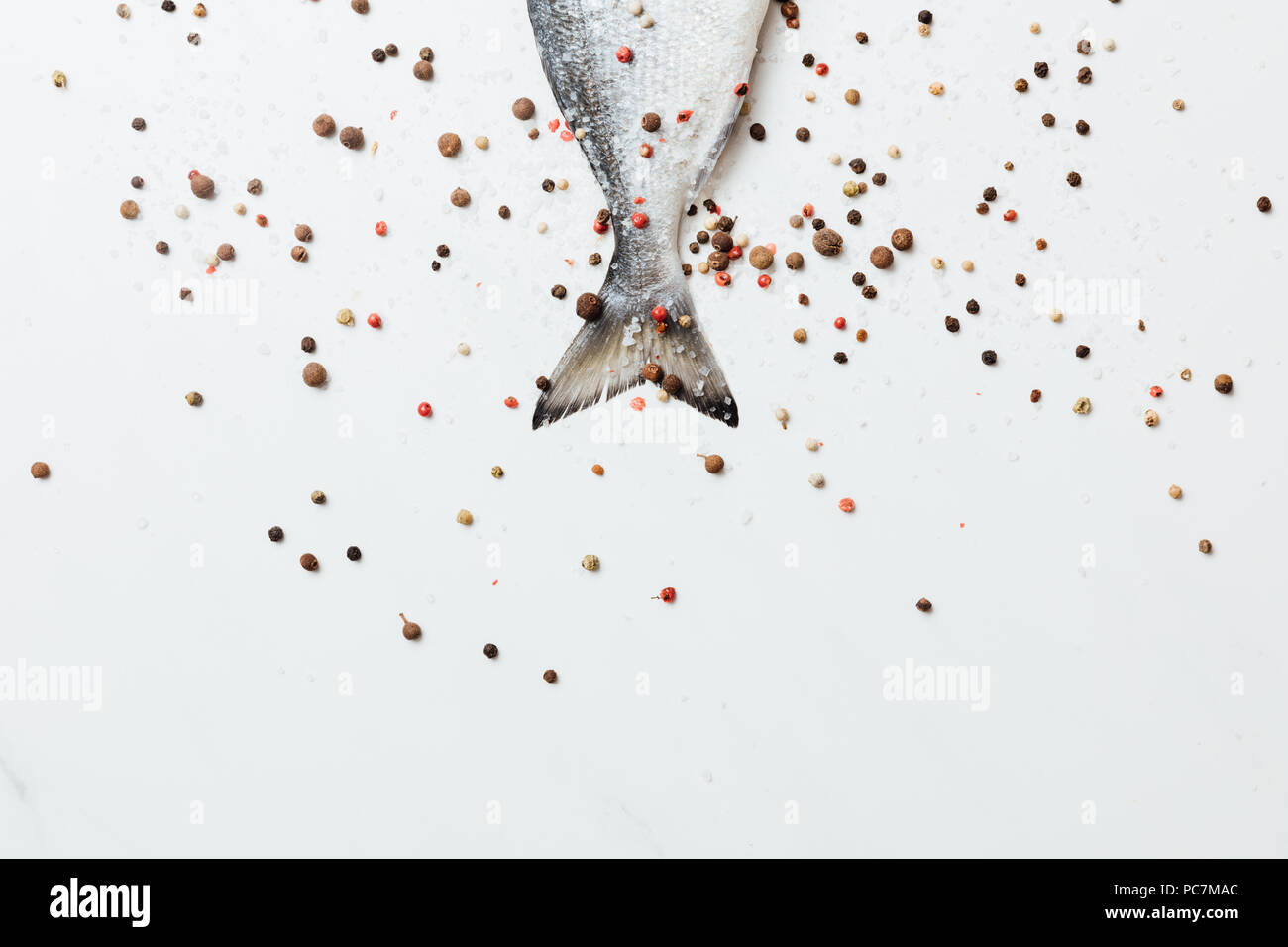 Sea fish seasoned with pepper and salt isolated on white Stock Photo ...