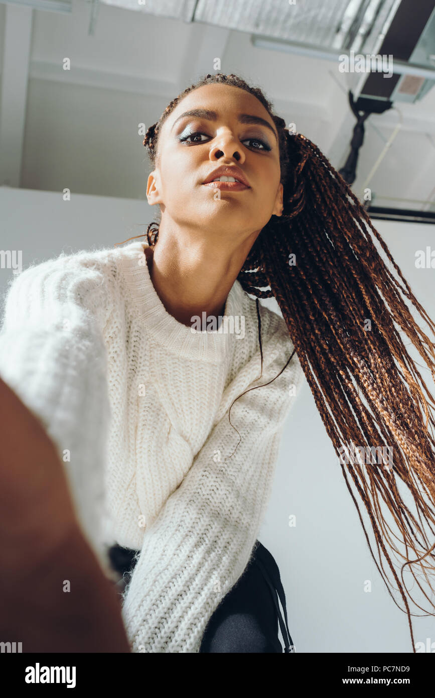 low angle view of stylish young african american woman looking at ...