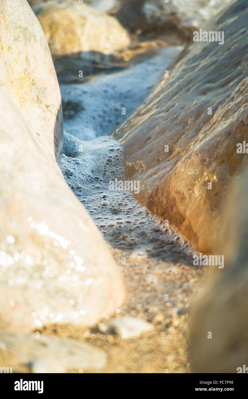 A close up of bubbles of a small wave / tide movements washing up ...