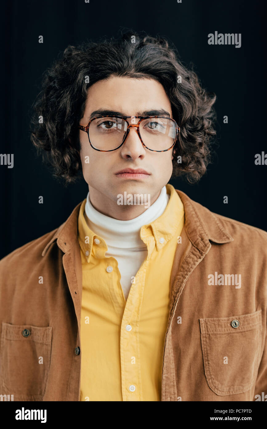 Portrait of male fashion model with curly hair in eyeglasses isolated ...