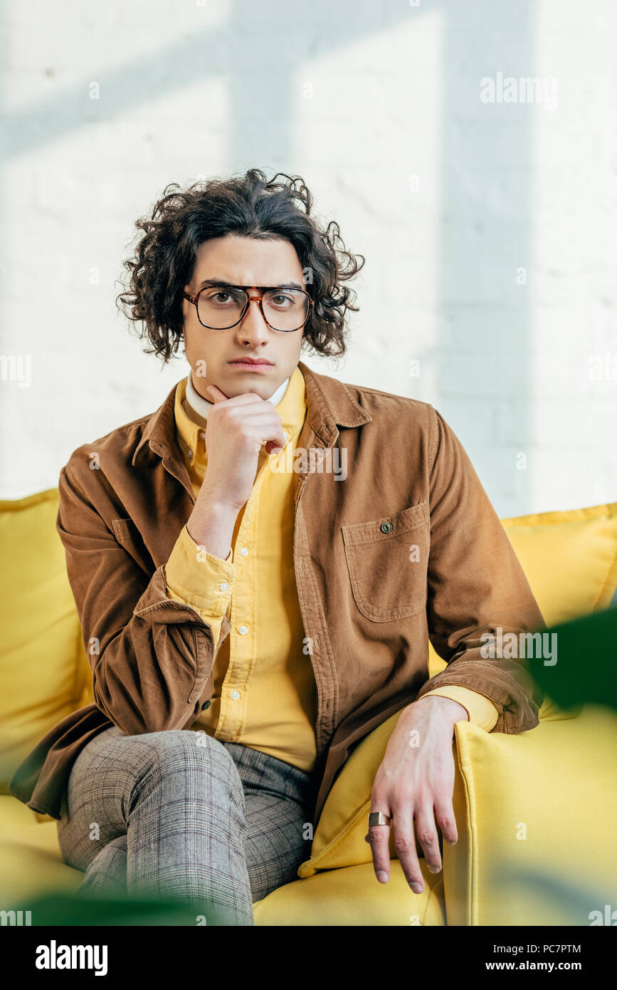 Male fashion model with eyeglasses holding hand on chin Stock Photo - Alamy