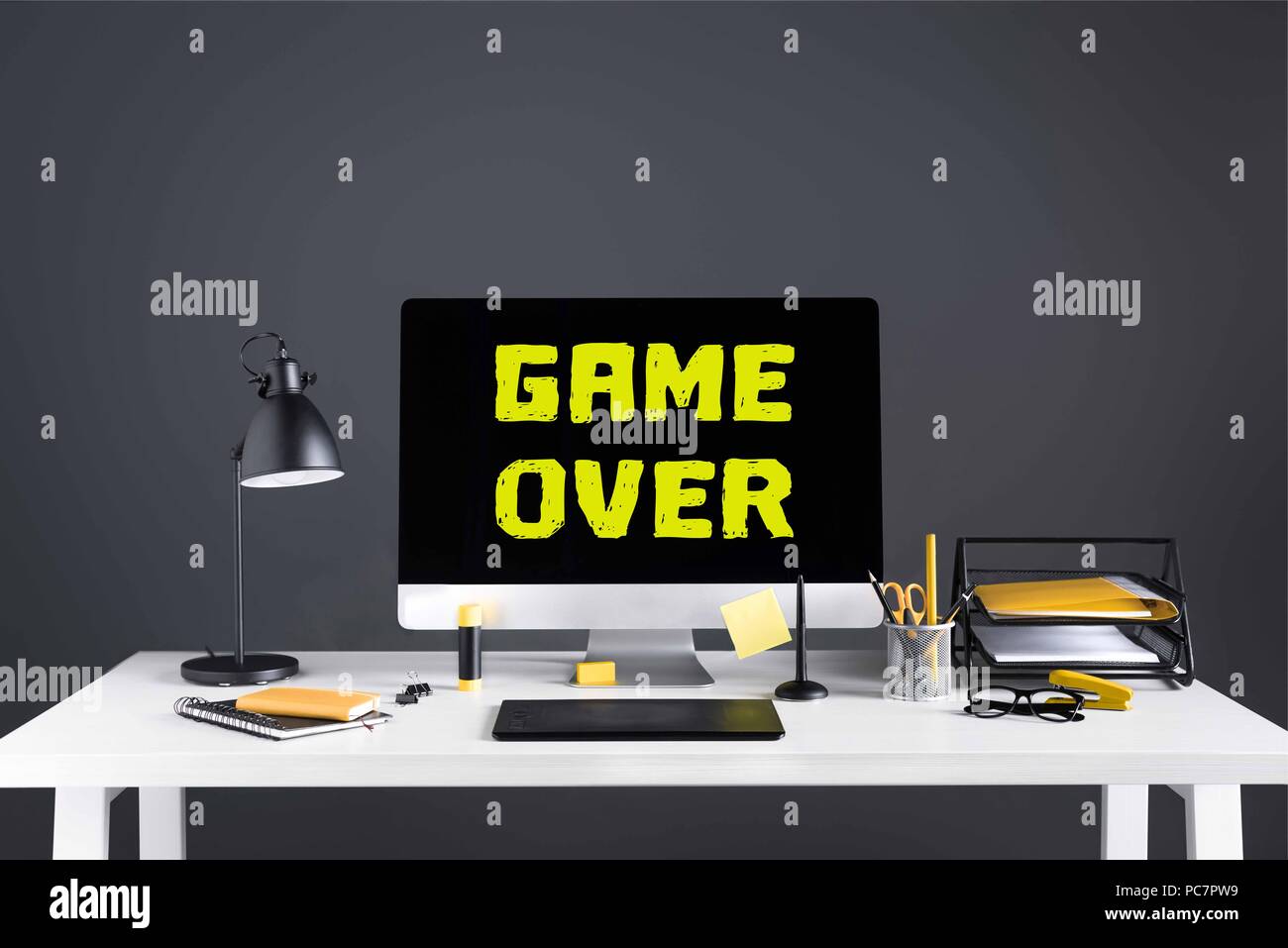 desktop computer with game over inscription on screen, graphics tablet ...