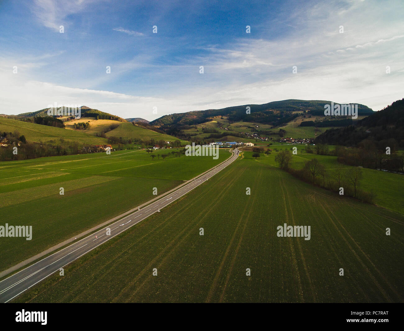 Aerial view of spectacular landscape with road, blue sky and green ...