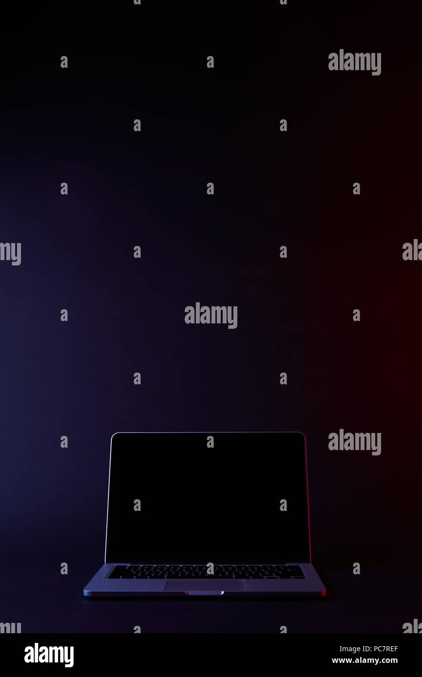 one turned off laptop with blank screen on dark surface Stock Photo - Alamy