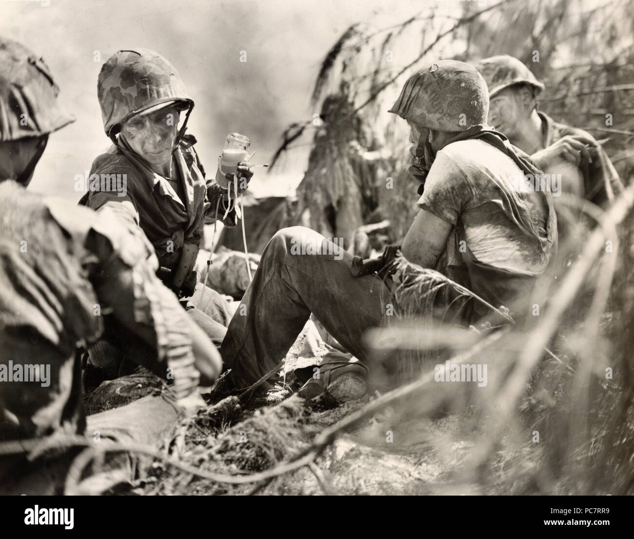 Navy corpsman administers blood plasma to wounded marine during heavy ...