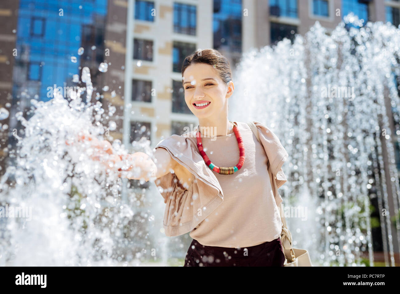 Positive delighted woman feeling splashes of water Stock Photo - Alamy
