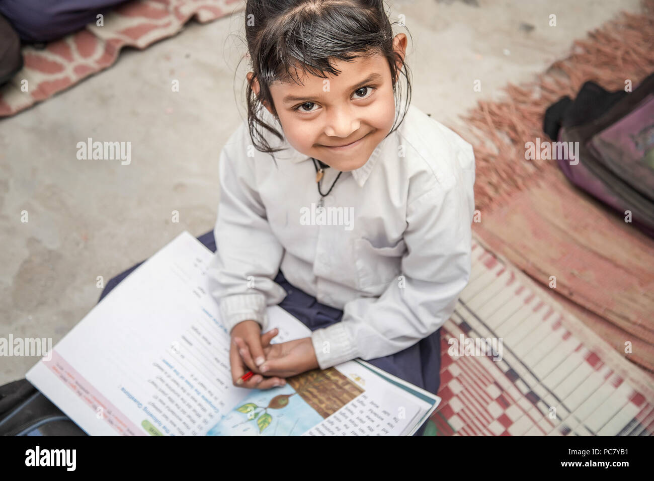 Girl sitting on the floor of her government primary school in uniform ...