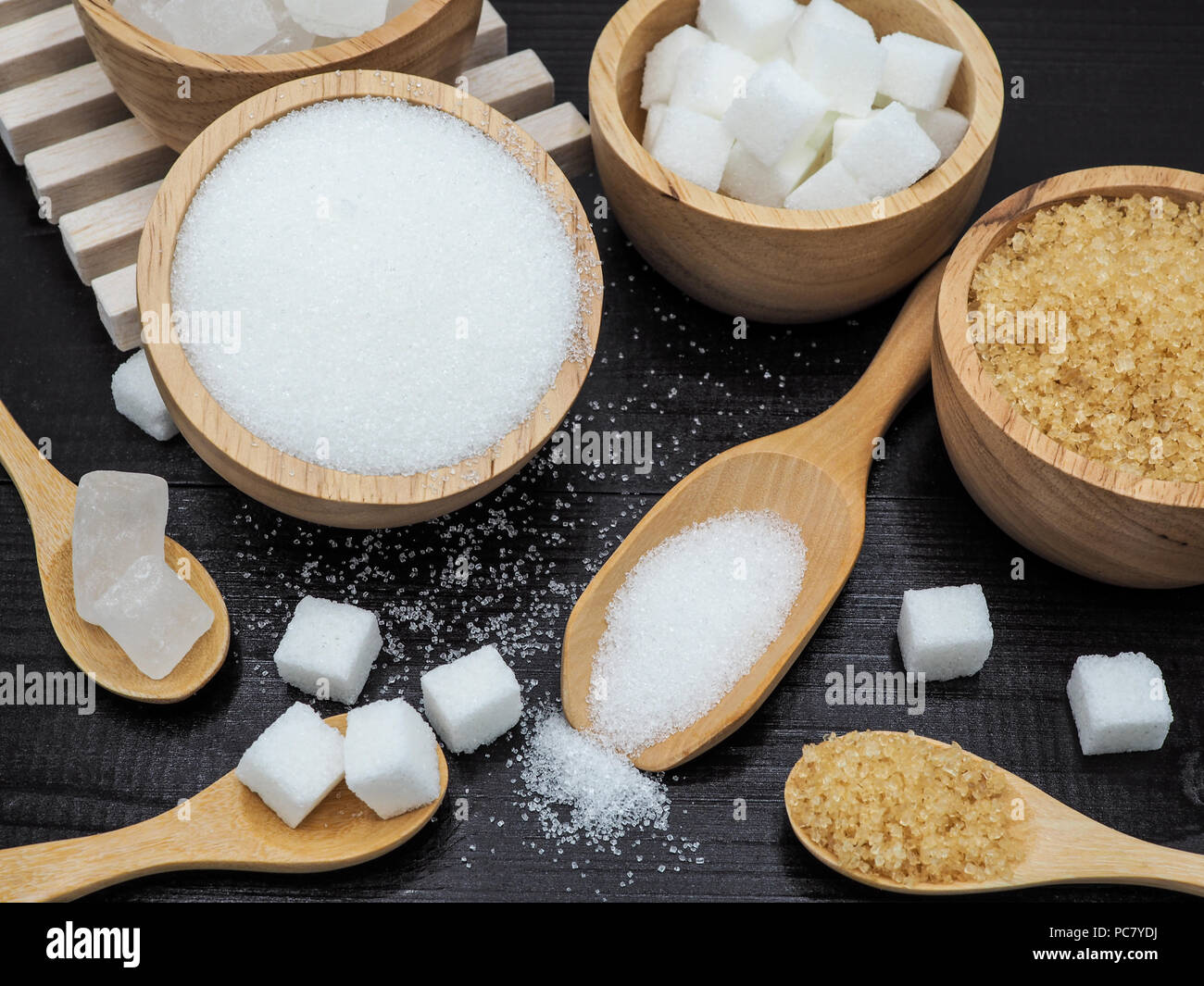 Wooden bowl and spoon with sugar cube on dark wood background Stock ...